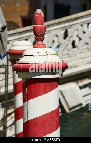 Red and white striped gondola mooring posts on the Grand Canal, in ...