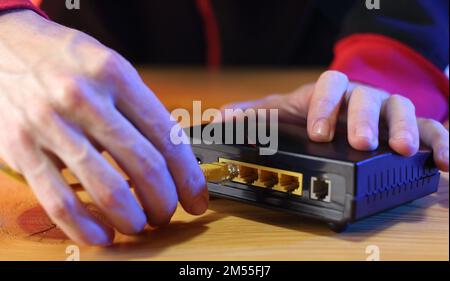 connecting internet cable to old adsl modem on table by background ...