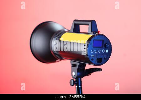 studio flash on a tripod of different colors against a pink wall Stock ...