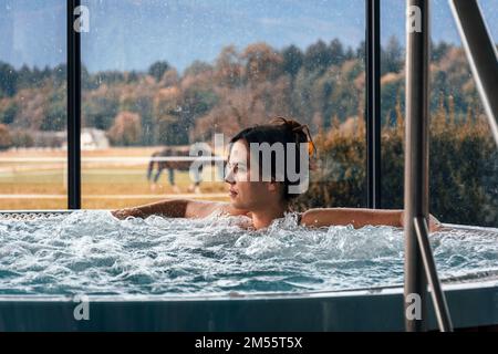 A closeup shot of a female taking a therapy bath in a jacuzzi wearing a ...