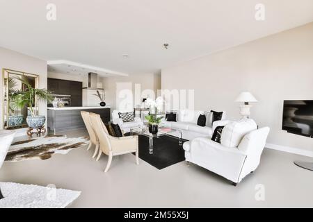 a living room with white couches and television on the wall in front of ...