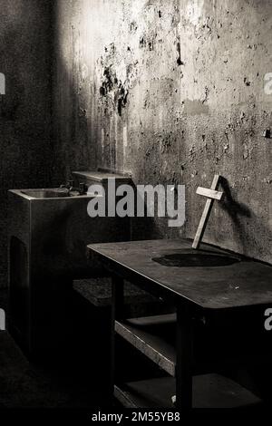 Wooden Christian cross and a cellmate metal sink in a cells in a ...