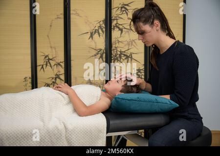 Caucasian woman practicing osteopathy on a child in her office Stock ...