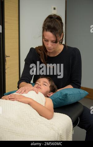Caucasian woman practicing osteopathy on a child in her office Stock ...