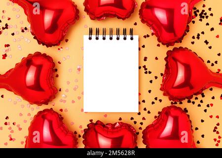 Empty notepad mockup and inflatable foil balloon on a pink glittering ...