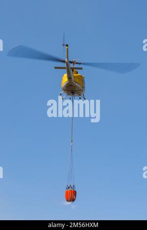 A vertical shot of a firefighting helicopter extinguishes a fire Stock ...