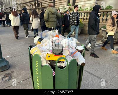 Overflowing garbage recepticles mostly filled with one use coffee cups ...