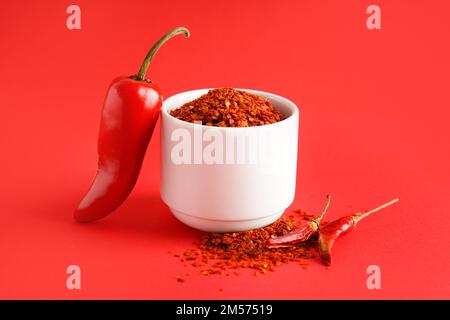 Bowl of chipotle chili flakes on color background Stock Photo - Alamy