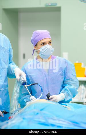 Focused look of female surgeon during surgery. A female doctor performs ...