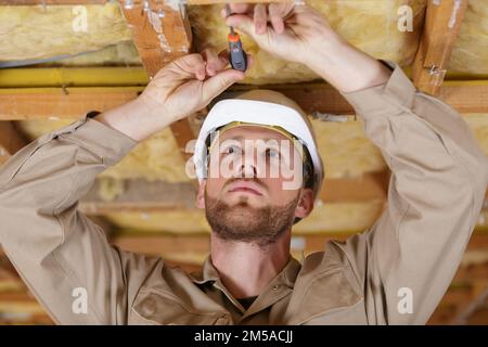 handsome young man fixing ceiling panel with pliers Stock Photo - Alamy
