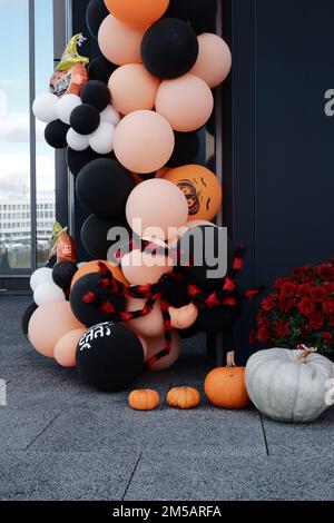 Composition of colorful Halloween balloons and pumpkins with a bouquet ...
