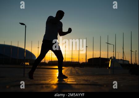 A man trains boxing at sunset outdoors Stock Photo - Alamy