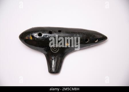 A closeup of an ocarina old wind musical instrument on a white ...