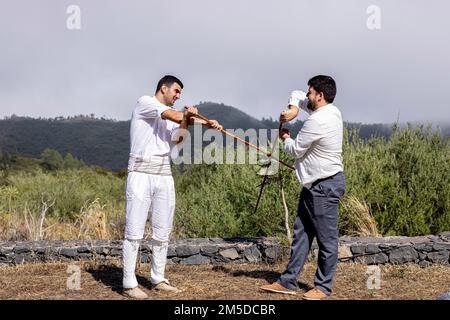 Two young men demonstrate the art of stick fighting, juego del palo, at ...