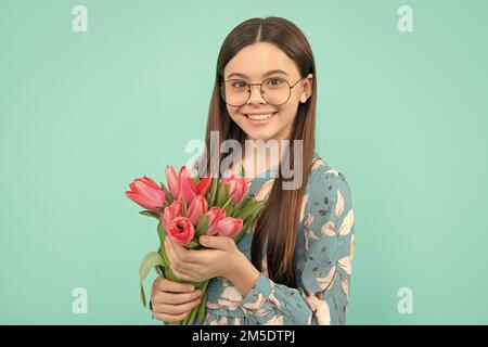 glad child in glasses with tulips. mothers or womens day. kid hold ...