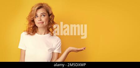 pondering redhead woman portrait isolated on yellow background ...