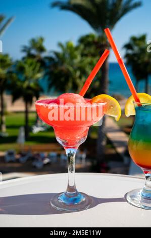 Colourful cold Strawberry daiquiri and Rainbow Paradise cocktails ...