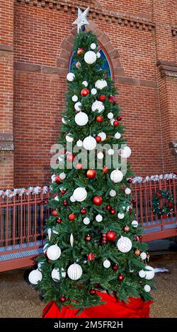 Decorated Christmas tree with ornaments and pine cones against a ...