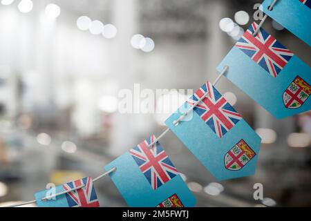 A garland of Fiji national flags on an abstract blurred background ...