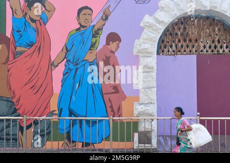 A woman passes a colorful wall painting at Sassoon Docks, Colaba ...
