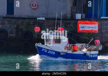 A lobster fishing boat returns to harbour with their fresh catch and ...