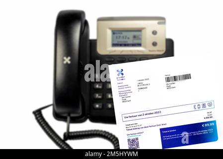 Invoice in front of black IP desktop telephone and internet modem from ...