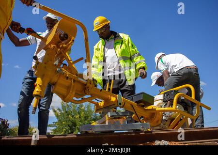 Workers Using a Mechanical Power Wrench to Bolt a Railway Track ...