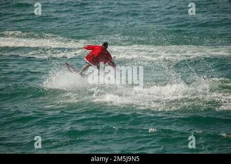 Palestinian surfers dressed in Santa Claus outfits surfing in ...