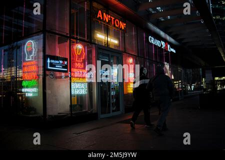 People passing by restaurant's windows illuminated at night. Moscow ...