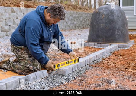 In process of laying stones pathway paving, professional paver worker ...