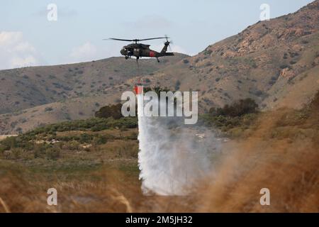 A Cal Fire Helicopter drops water on a fire hot spot. The Post Fire ...