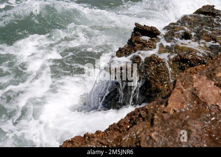 Wave crashes on rock Stock Photo - Alamy