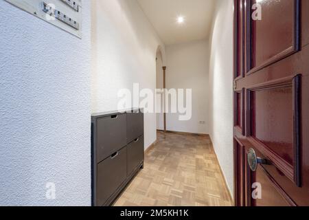 Entrance hall of a house with an L-shaped corridor with door carpentry ...