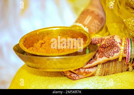 Indian Hindu bride with turmeric paste applied on her face having fun ...