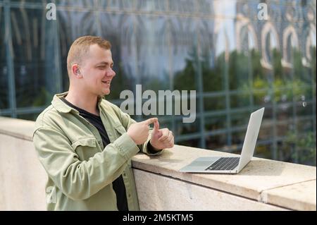 Caucasian man communicates in sign language via video link on laptop ...