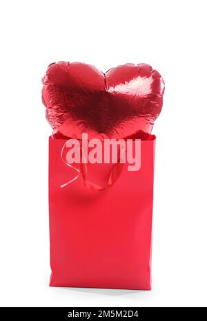 Shopping bag with heart-shaped balloon for Valentine's Day on blue ...