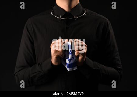 Jewish man with barbed wire around his neck holding flag of Israel on ...
