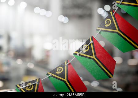 A garland of Vanuatu national flags on an abstract blurred background ...
