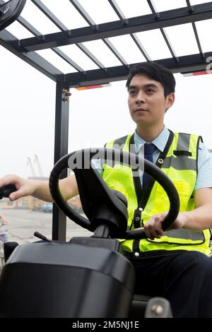 Logistics warehouse workers forklift driving Stock Photo - Alamy