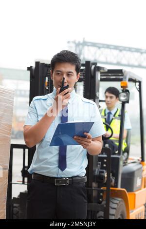 Logistics warehouse management personnel with interphone Stock Photo ...