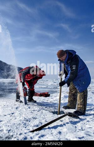 Digging a hole in the ice for scuba diving, Lake Baikal, Olkhon Island ...