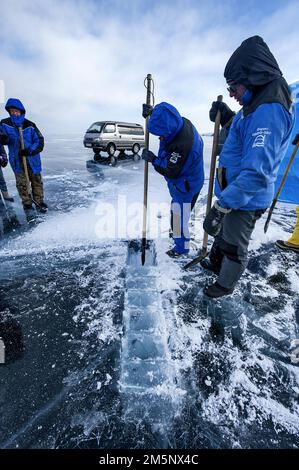 Digging a hole in the ice for scuba diving, Lake Baikal, Olkhon Island ...