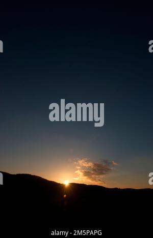A beautiful shot of a sunsets sky over a dark field Stock Photo - Alamy