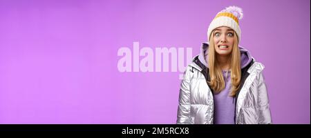 Awkward worried cute timid blond girl in silver jacket hoodie winter ...