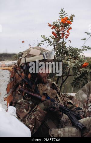 A Ukrainian defender during enemy artillery fire on the front line. War ...