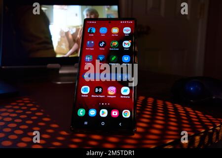 Cell Phone with bright apps showing on table shadow on Stock Photo - Alamy