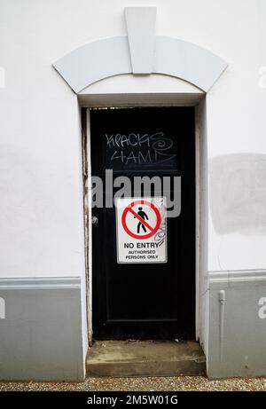 Graffiti and tagging on a black door Stock Photo - Alamy