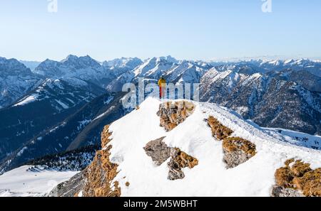 Ski tourers at the summit of Schafreuter, view of snow-covered mountain ...