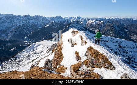Ski tourers at the summit of Schafreuter, view of snow-covered mountain ...