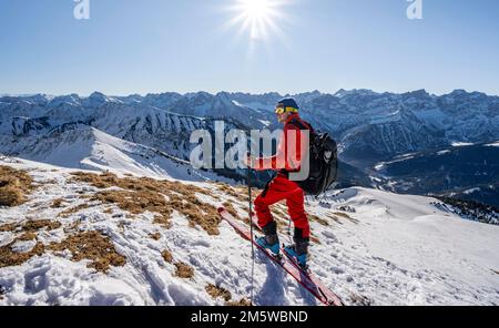 Ski tourers at the summit of Schafreuter, view of snow-covered mountain ...